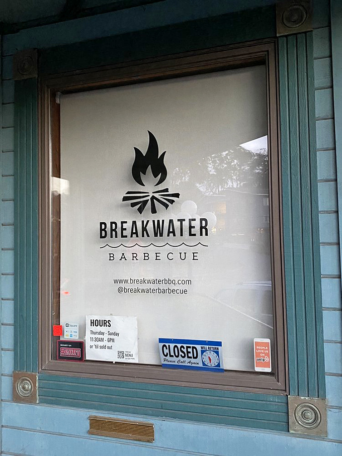 The window sign tells you everything you need to know: simple hours, straightforward branding, and a promise of smoke-infused delights inside.