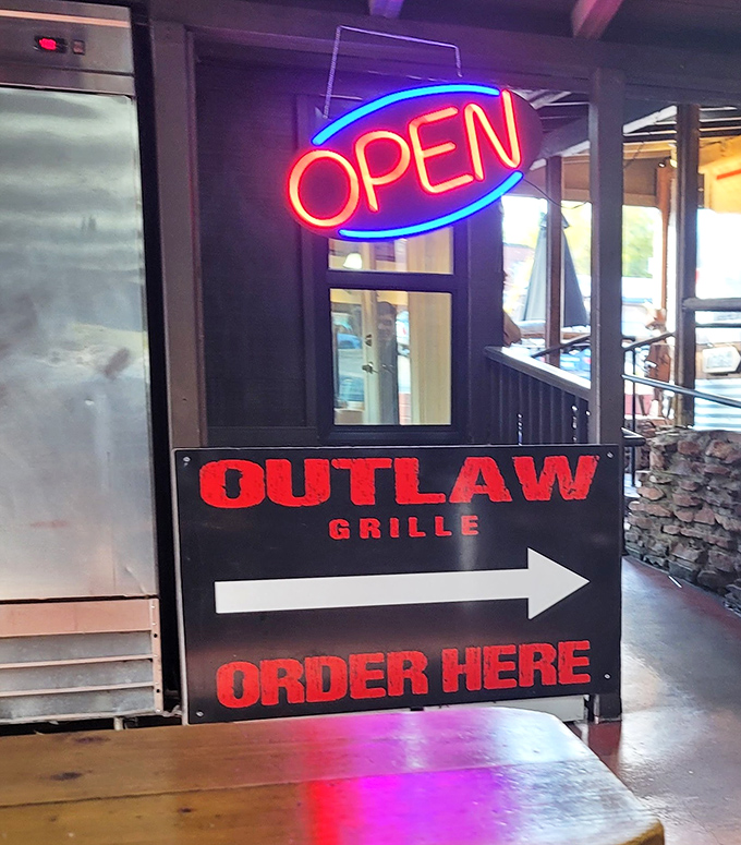 The neon "OPEN" sign might as well say "SALVATION" for hungry travelers who've been dreaming of these burgers for miles.