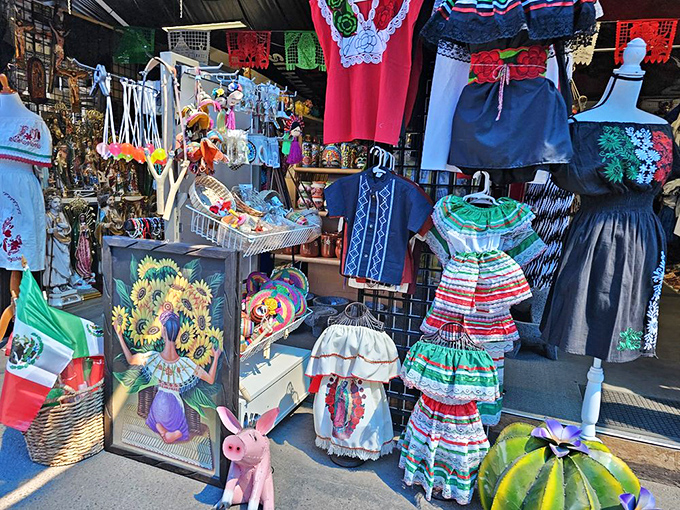 A celebration of Mexican cultural heritage through vibrant textiles and traditional dresses. Folk art meets fashion in this colorful vendor display.
