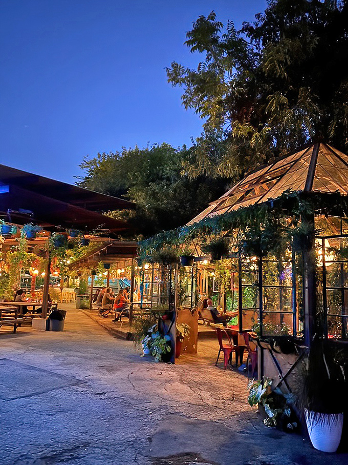 As night falls, Elsewhere's greenhouse seating areas glow with fairy-tale charm - a secret garden for grown-up adventures.