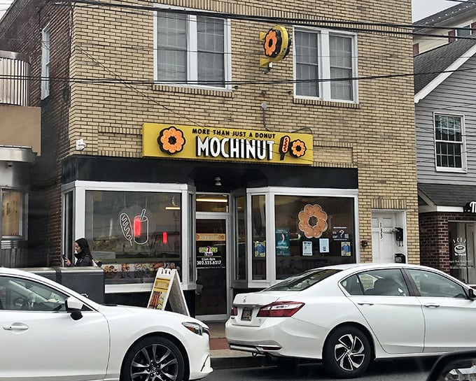 Flower-shaped mochi donuts await behind Mochinut's cheerful yellow storefront - a taste adventure worth taking.
