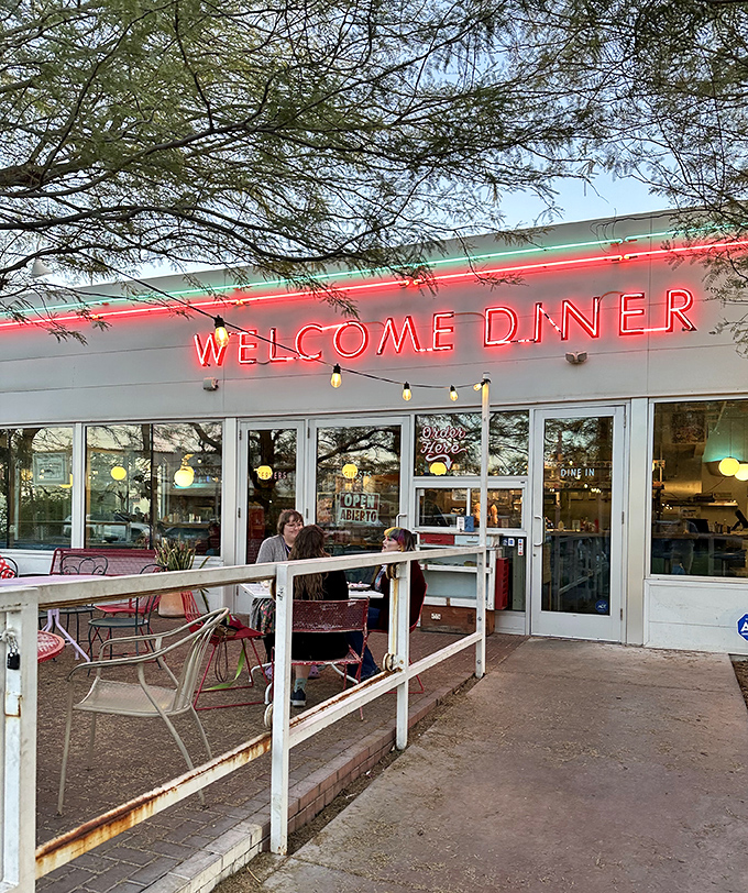 The glowing neon of Welcome Diner at dusk &ndash; where Phoenix's food scene shines as bright as the desert stars.