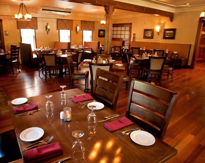 Tables arranged for both intimate dinners and larger gatherings, with burgundy napkins adding pops of color to the elegant space.