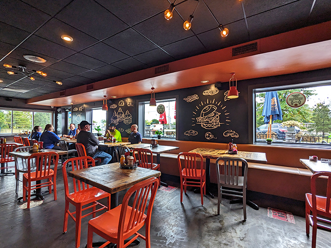 Neon burger art and bright orange accents create an atmosphere that's equal parts playful and serious about good food.