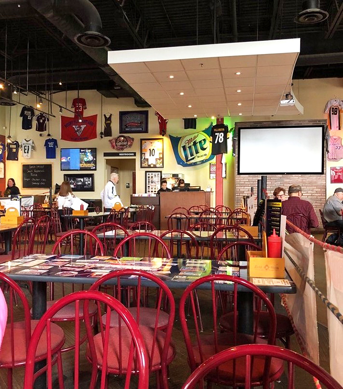 Red chairs stand at attention like loyal soldiers, ready to support hungry patrons through multiple quarters of football and plates of wings.