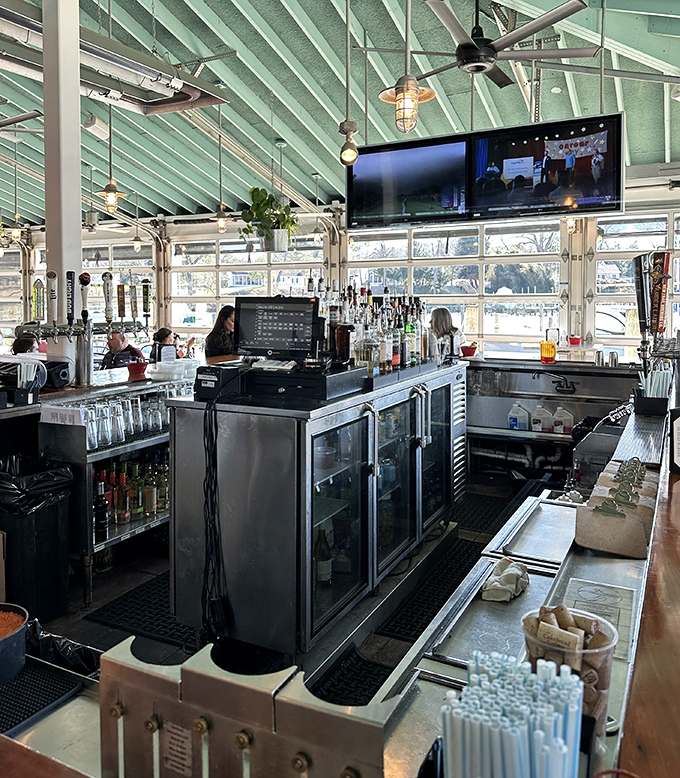Behind this bar, mixologists craft cocktails worthy of their crabby companions. The ceiling's blue-green hue echoes the bay just outside.