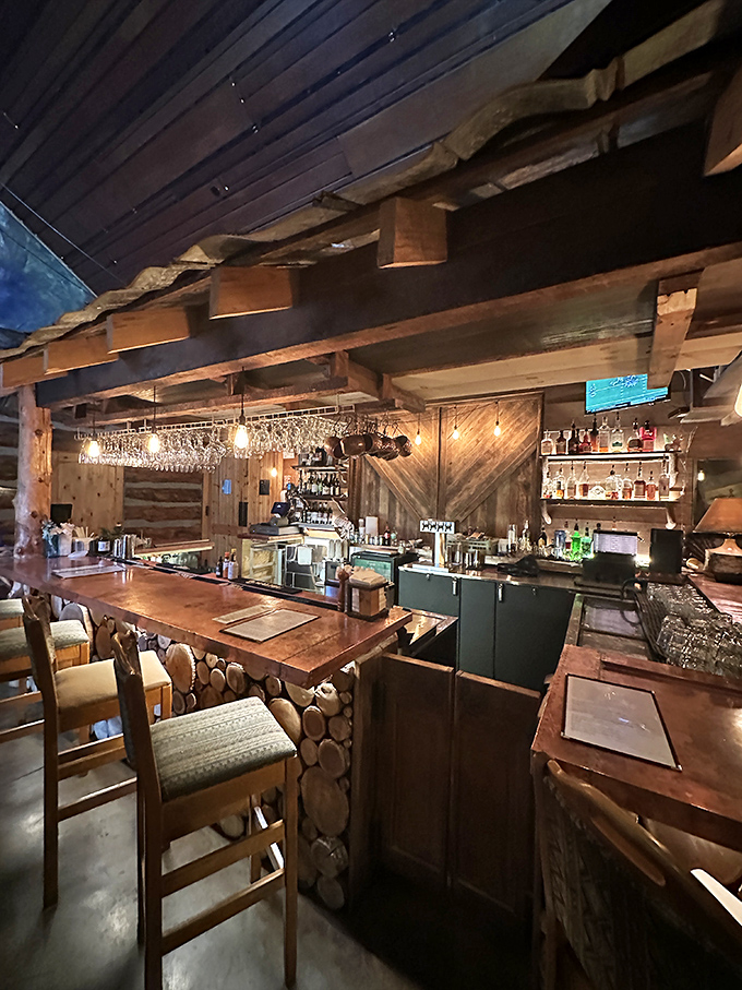 The bar area showcases masterful woodwork and warm lighting. Where bourbon sipping becomes an art form worthy of the surroundings.