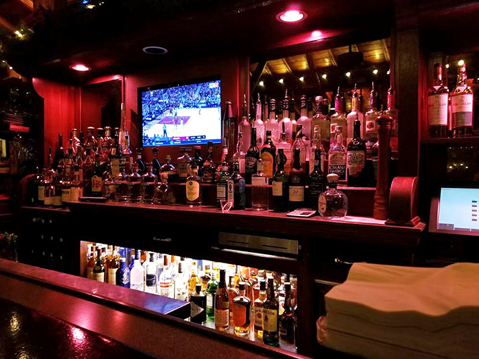 Warm lighting illuminates bottles like liquid jewels behind the bar, creating the perfect backdrop for that pre-dinner Manhattan.