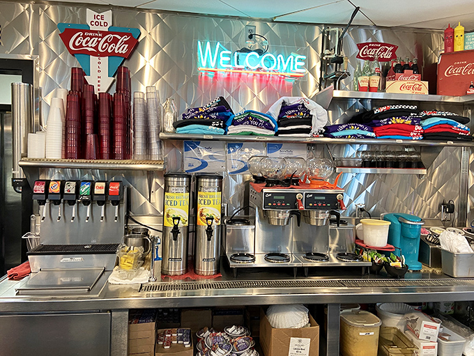 The beverage station gleams with vintage Coca-Cola signage and modern efficiency, while merchandise waits for those who want to take a piece of nostalgia home.