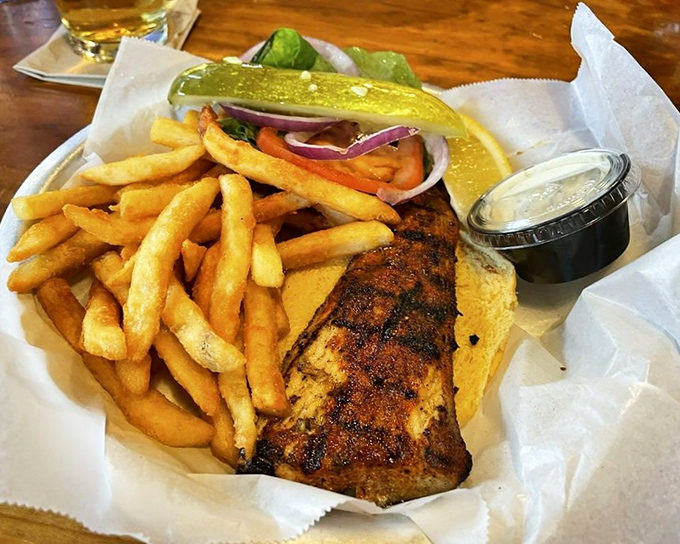 Blackened perfection between bread! This mahi sandwich delivers smoky spice and flaky fish in perfect harmony with crisp veggies and those addictive fries.
