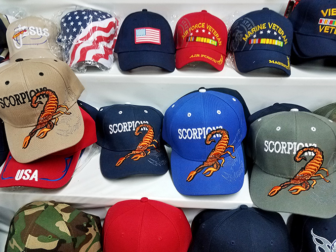 Military pride and scorpion swagger share shelf space in this hat display, where headwear becomes a statement of identity.
