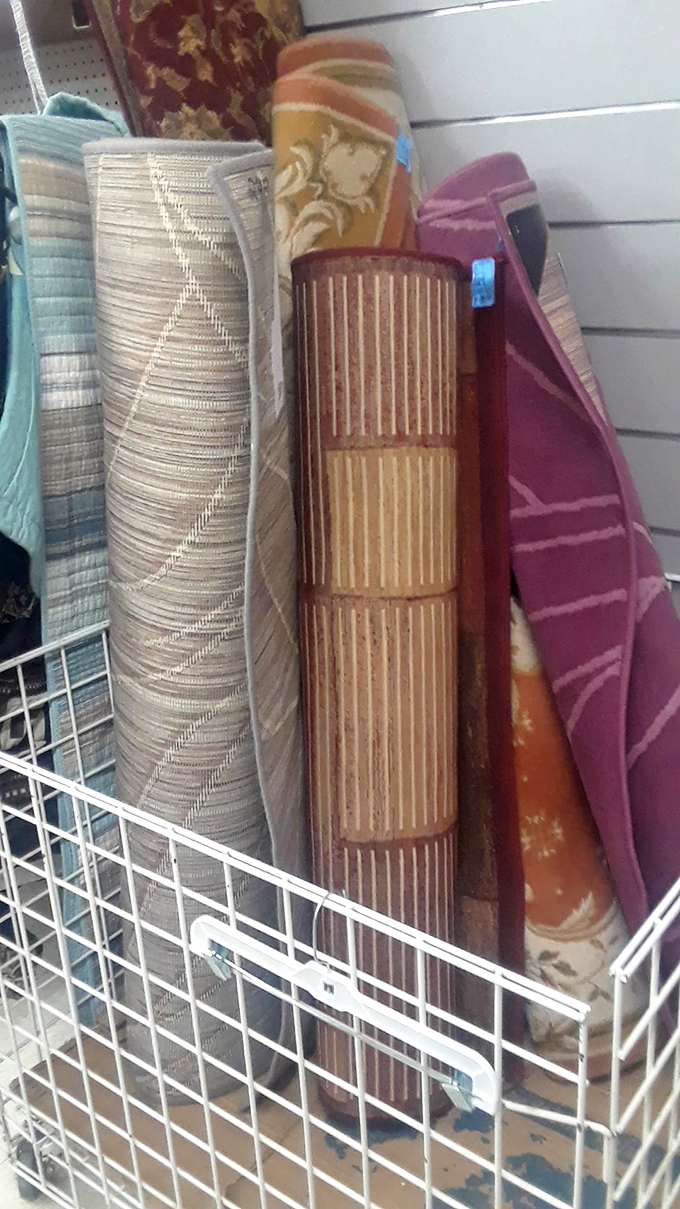 Rolled rugs standing at attention like textile soldiers. These floor coverings have stories woven into every fiber, ready for new rooms to transform.