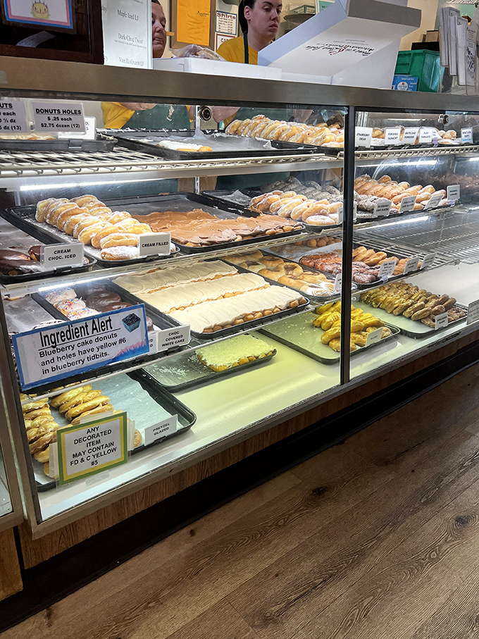 The display case—where dreams and diets go to die. Each tray contains not just pastries, but moments of pure, unadulterated joy.