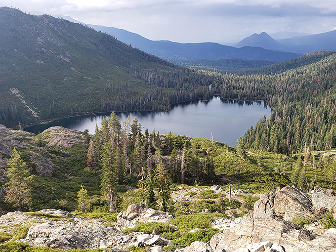 Castle Lake mirrors the surrounding wilderness in perfect stillness. This alpine gem offers swimming in summer and ice fishing in winter&mdash;nature's seasonal mood swings.