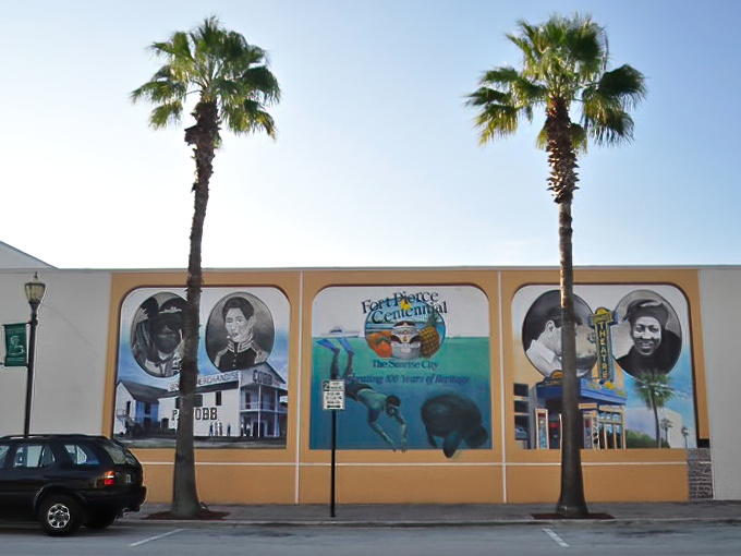The Centennial Mural captures Fort Pierce's rich history in vibrant colors, telling stories that span generations under the watchful gaze of twin palms.