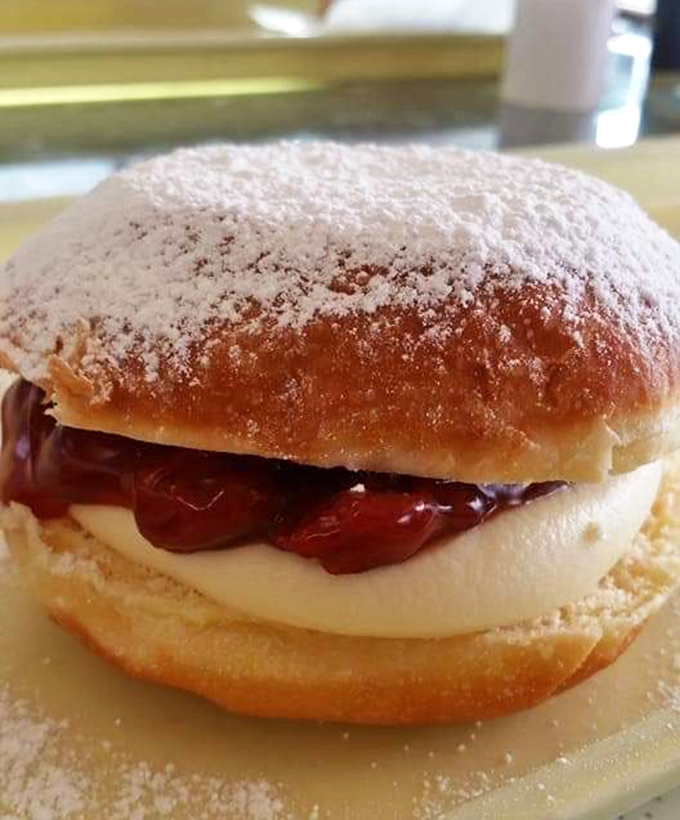 A powdered sugar-dusted sandwich of joy, where cream and fruit jam create the ultimate breakfast indulgence.