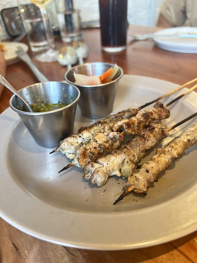 Chicken skewers that look like they've been kissed by fire, served with dipping sauces that make each bite a new adventure.