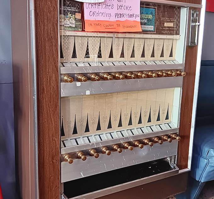 The vintage cigarette machine stands as a relic of bygone days, now serving as a conversation piece rather than its original purpose.