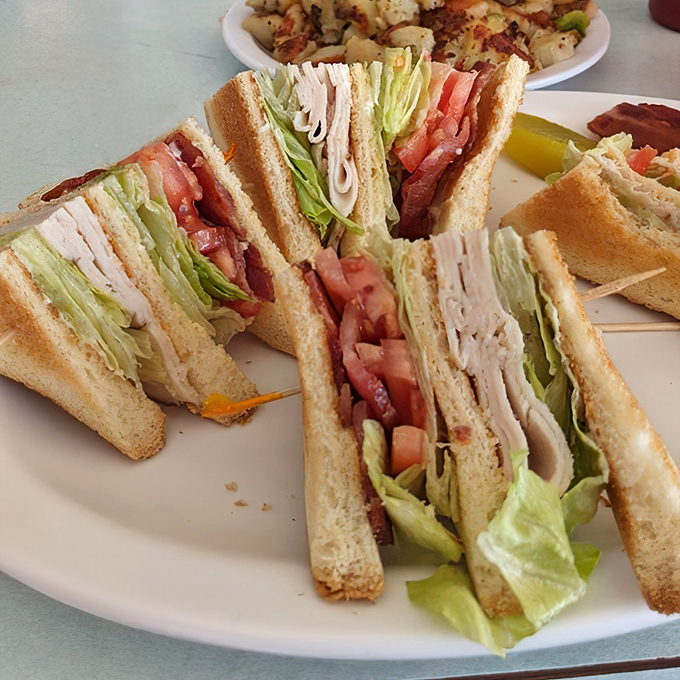 The club sandwich&mdash;a towering achievement of turkey, bacon, and vegetables that requires both hands and a strategic approach.