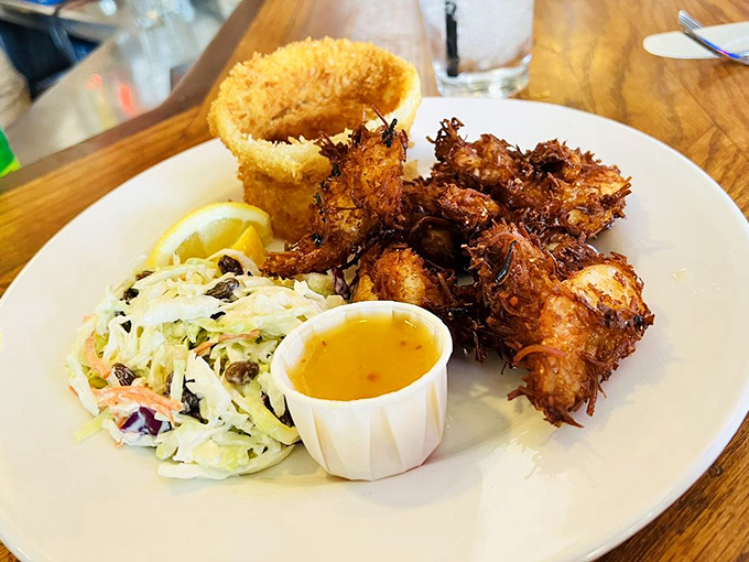 Coconut shrimp that crunch louder than your retirement portfolio. The coleslaw provides a refreshing counterpoint to the decadence.