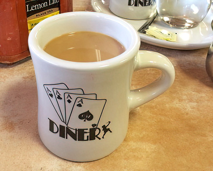 The Four Aces coffee mug&mdash;holding the elixir that transforms morning zombies into functioning humans one sip at a time.