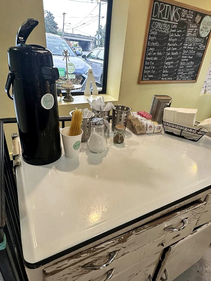 The coffee station stands ready for caffeinated magic, with the chalkboard menu looming like a delicious decision tree in the background.