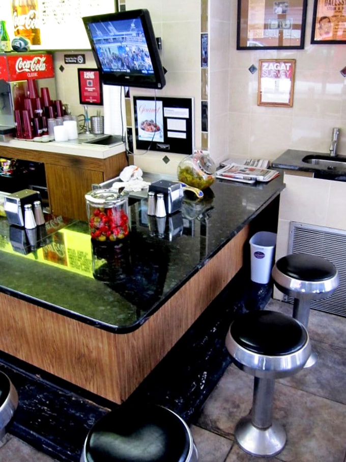 The counter setup offers front-row seats to the cheesesteak show. Part dining area, part theater for hungry spectators.