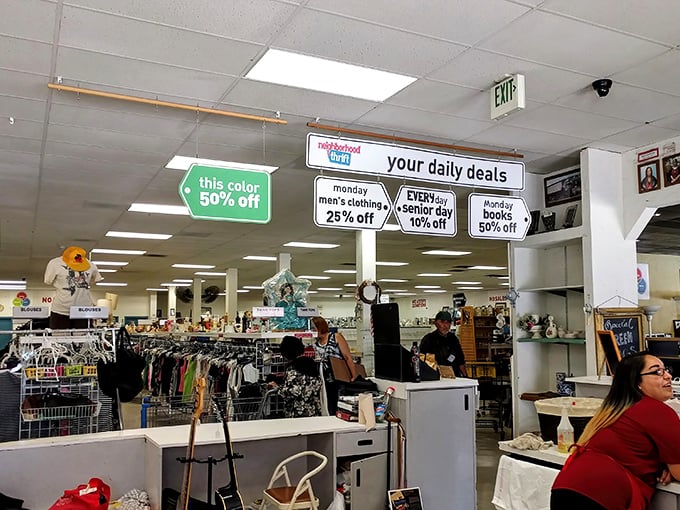 Daily deals hang from the ceiling like thrifting commandments. That green sign promising 50% off might be the best news you'll get all day.