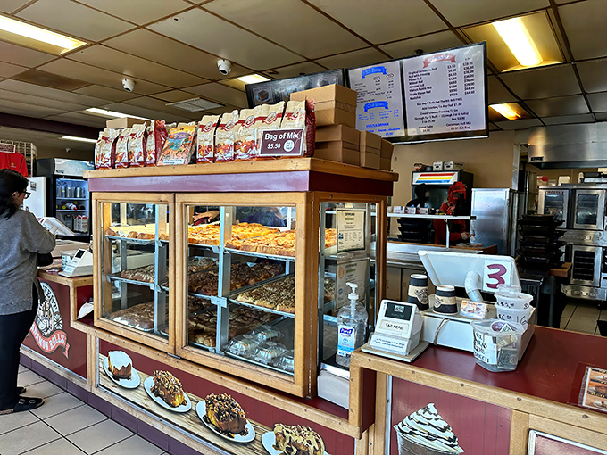 The display case: a glass-fronted museum of carbohydrate artistry. Each shelf a different exhibit in the gallery of "Things Worth Breaking Your Diet For."