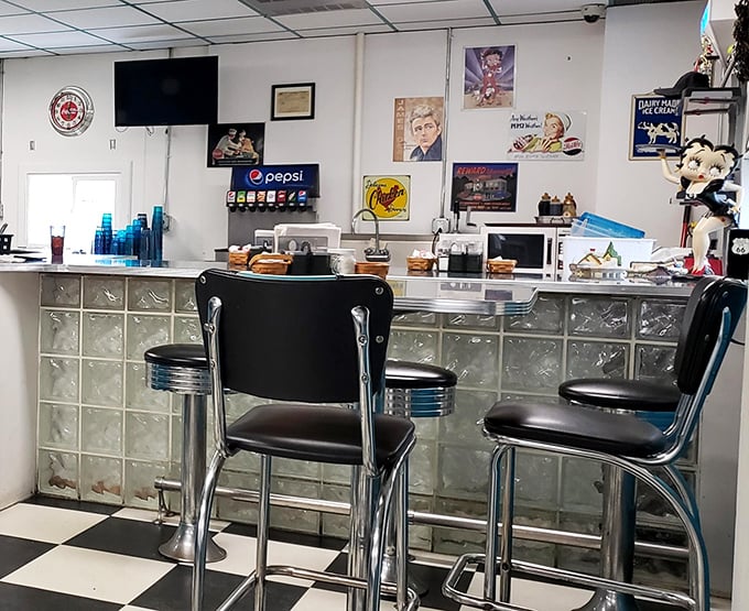 The counter where magic happens &ndash; chrome, glass blocks, and black-and-white checkered floors creating the perfect stage for breakfast theater.