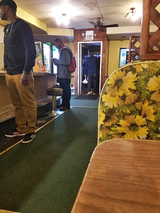 The floral upholstery and vintage decor create an atmosphere where strangers become friends united by the universal language of good food.