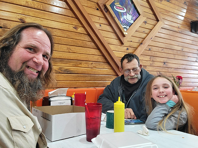 Happy diners enjoying the warm atmosphere and hearty food&mdash;creating memories that will bring them back to these orange booths time and again.