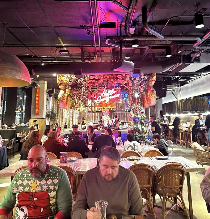 The dining room buzzes with the energy of shared discovery&mdash;each table embarking on their own culinary adventure under the glow of pink neon.