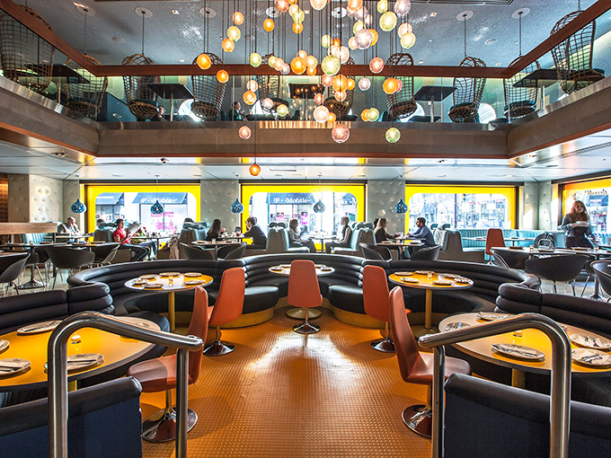 The main dining room feels like the Jetsons met Don Draper—colorful globe lights floating above curved booths like a mod solar system.