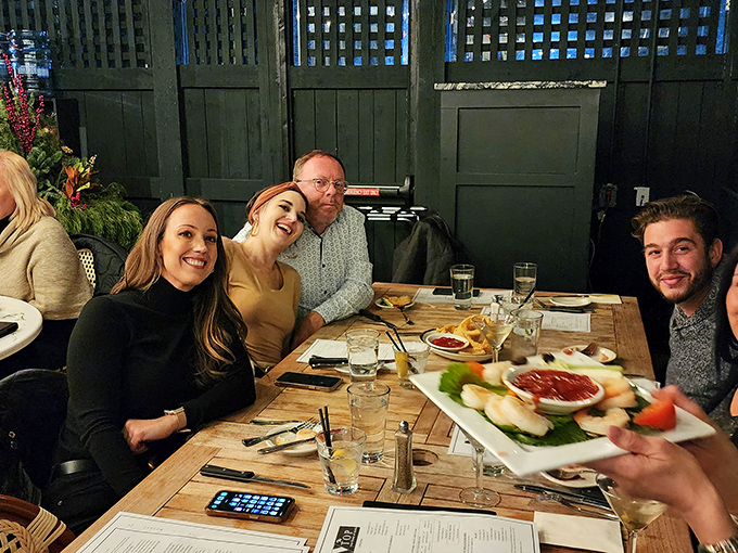 Happy diners sharing appetizers and stories&mdash;the universal language of good food bringing people together around the table.