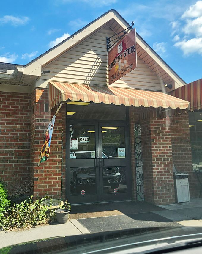 The entrance beckons with its striped awning and simple promise: authentic country store goodness awaits just beyond these doors.