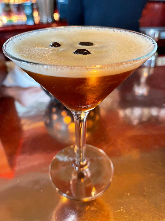 An espresso martini with coffee beans floating like little life rafts in a sea of caffeinated bliss.