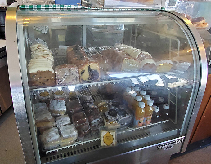 A pastry case that should come with a warning sign: "Resistance is futile." Baked goods arranged like treasures under glass, tempting even the strongest willpower.