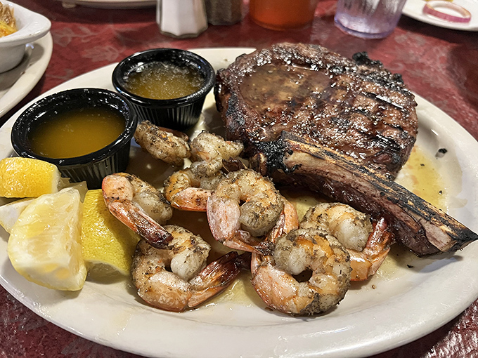 The surf-and-turf that launched a thousand food dreams – a ribeye with perfect char marks sharing the spotlight with succulent shrimp.