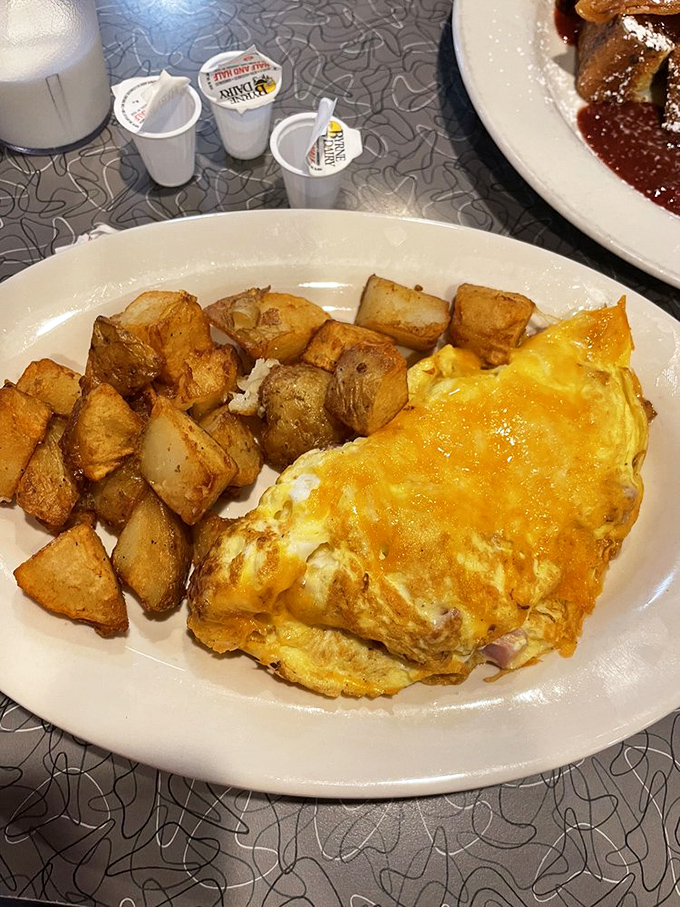 Ham and cheese omelet so fluffy it defies gravity, served with perfectly golden breakfast potatoes.