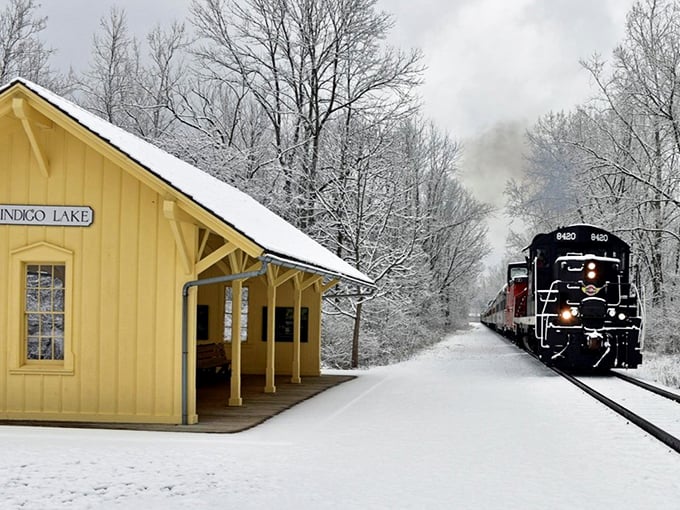 Indigo Lake Station stands frosted like a gingerbread house in winter, the approaching train bringing warmth and wonder to this snow-covered scene.