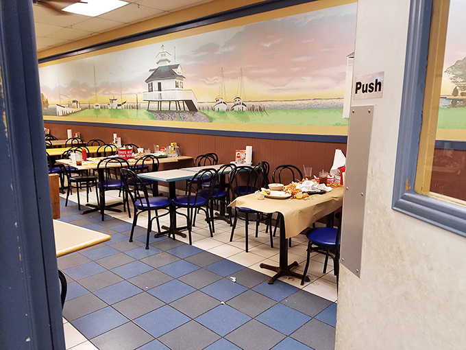 The lighthouse mural watches over diners like a silent guardian of seafood tradition. Those empty tables won't stay that way for long. 
