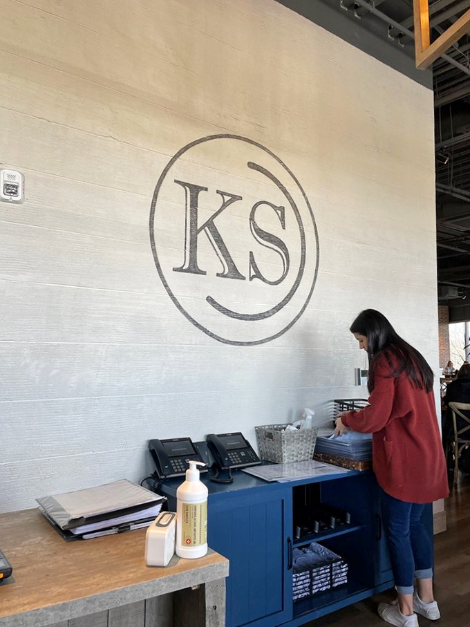 The minimalist "KS" logo against textured white walls &ndash; proof that sometimes the best restaurants whisper rather than shout.