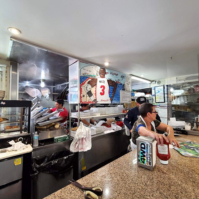 Behind the counter, where sandwich assembly becomes performance art and every order is handled with the precision of a NASA launch.