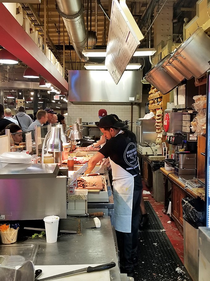 The kitchen dance: skilled hands move with practiced efficiency, slicing and assembling at a pace that never feels rushed despite the perpetual line.