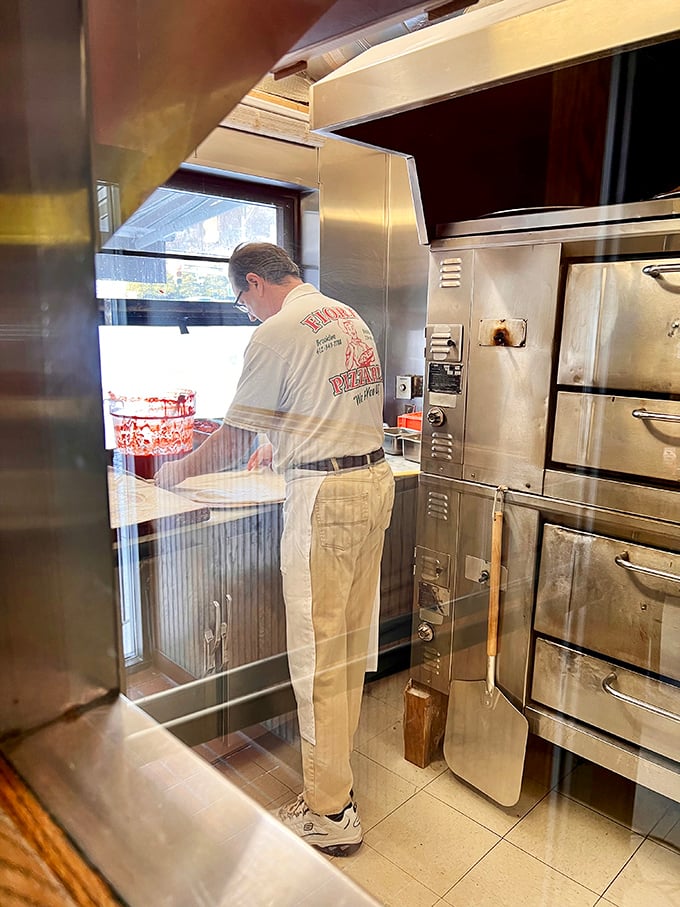 Behind the scenes magic where dough becomes dreams. The kitchen's well-worn equipment speaks to decades of consistent pizza perfection.