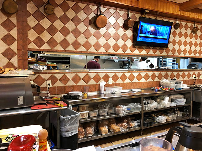 Behind the scenes where breakfast magic happens. Those diamond-patterned tiles and hanging pans speak of a kitchen that means business.