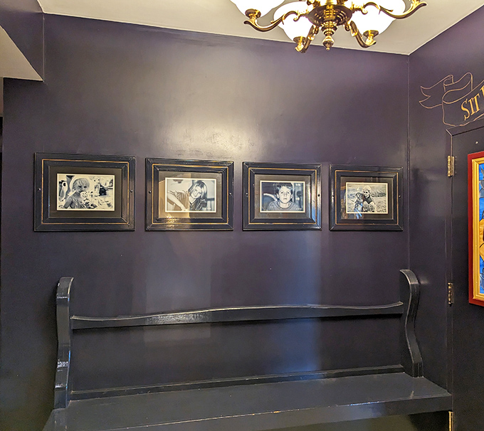 A quiet corner that whispers of conversations past, with navy walls that make the gold frames pop like exclamation points.