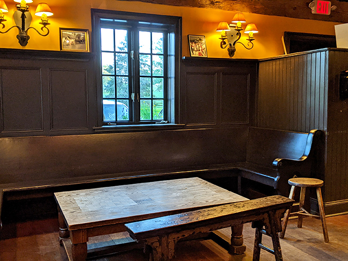 A corner table by the window &ndash; the most coveted real estate in the house. Dark wood paneling and bench seating create that authentic British pub atmosphere.