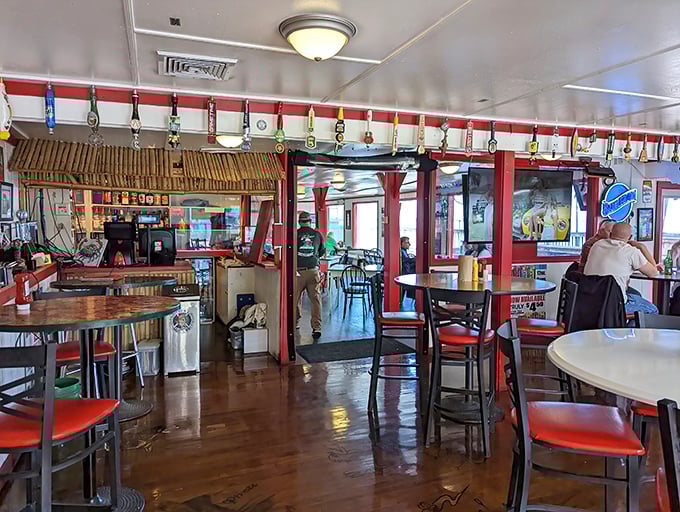 The dining room where beer tap handles line the ceiling like colorful stalactites. Red accents and wooden floors create the perfect seafood joint vibe.